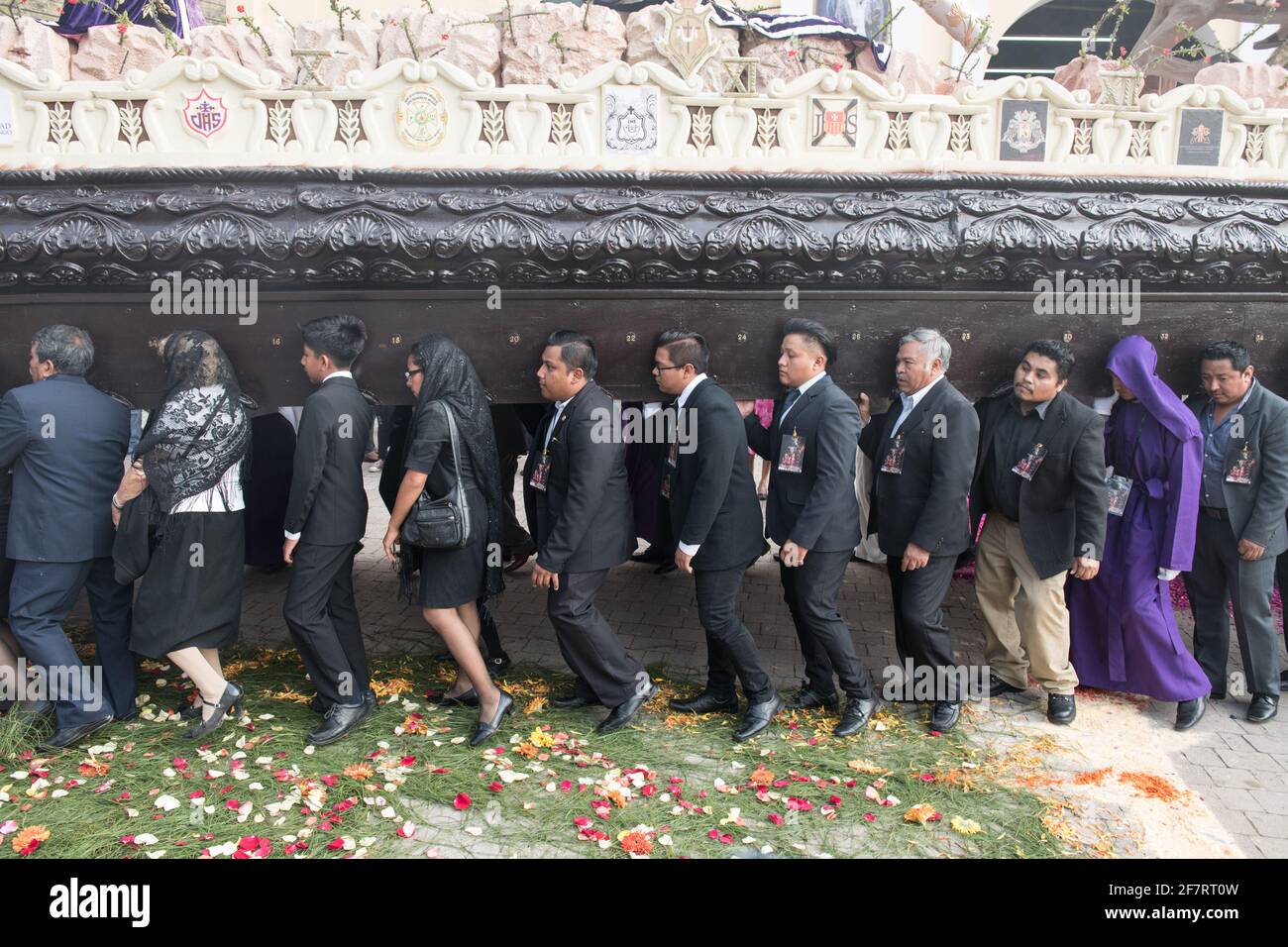 Well-dressed men in suits and women in traditional attire participate ...