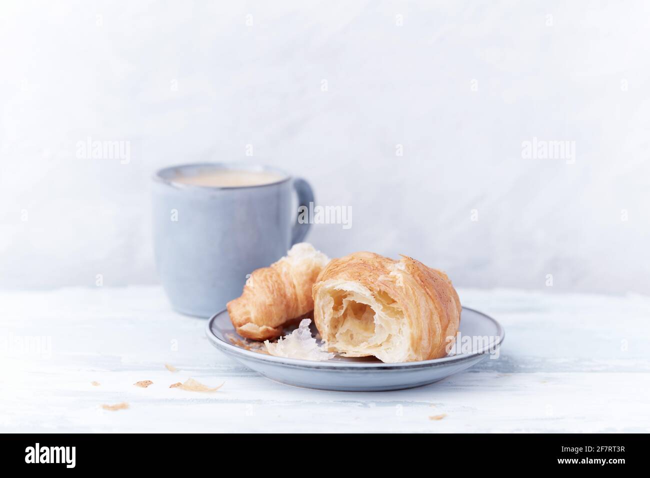 Croissant with coffee on bright wooden background. Close up. Copy space ...