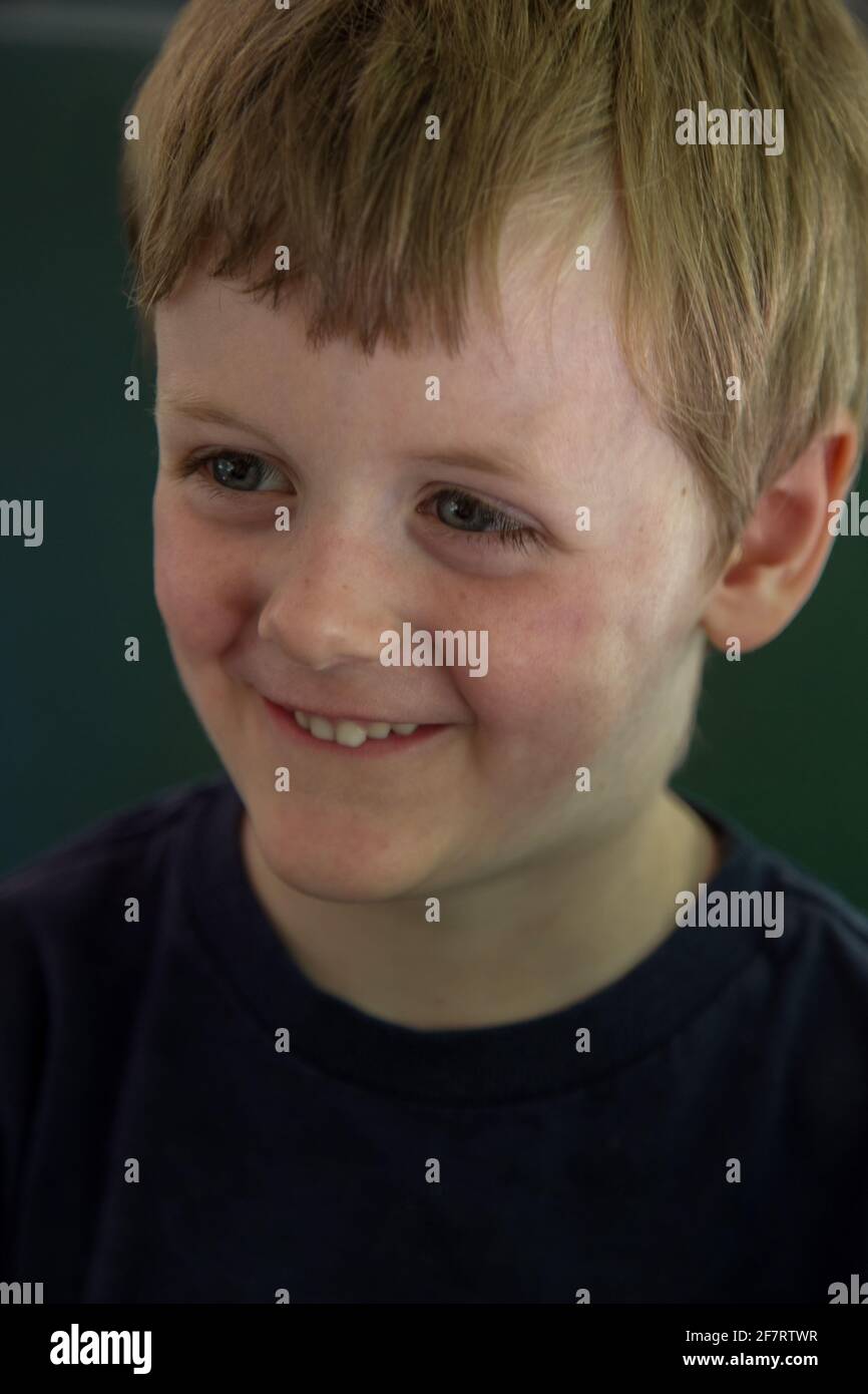 Smiling blonde boy looking to the left Stock Photo - Alamy