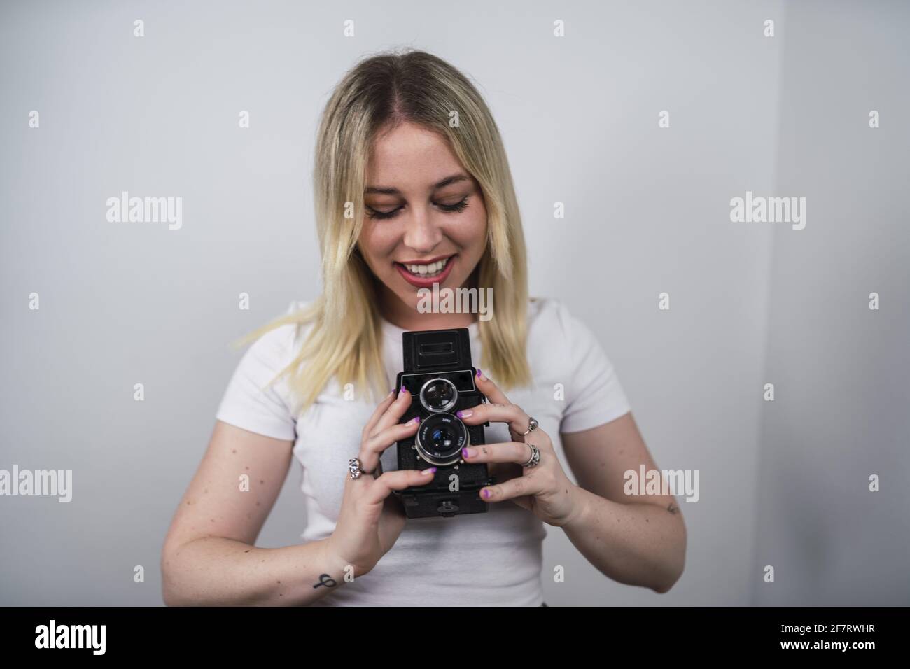 Smiling Spanish female holding a camera Stock Photo - Alamy