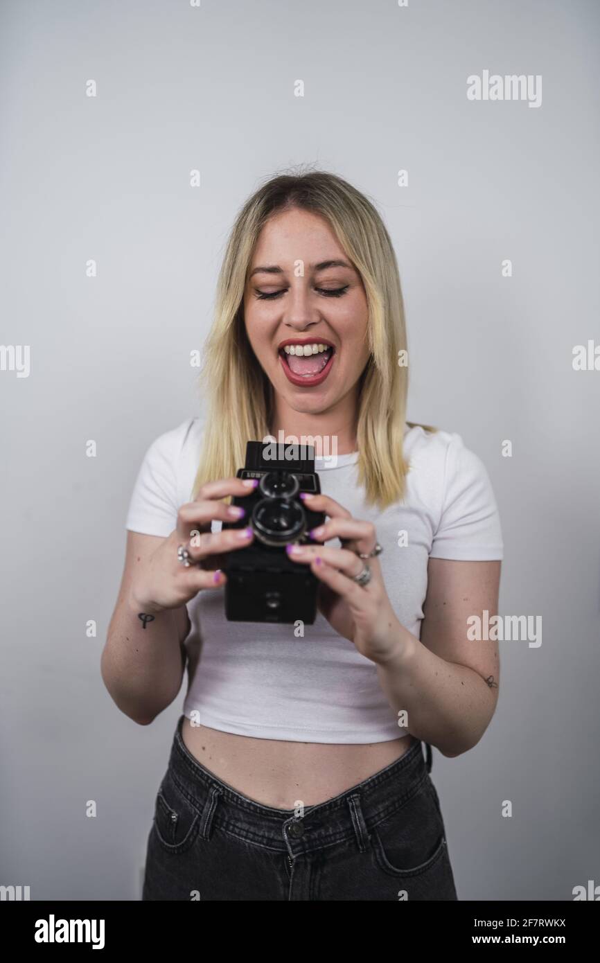 Vertical shot of a smiling Spanish female holding a camera Stock Photo ...