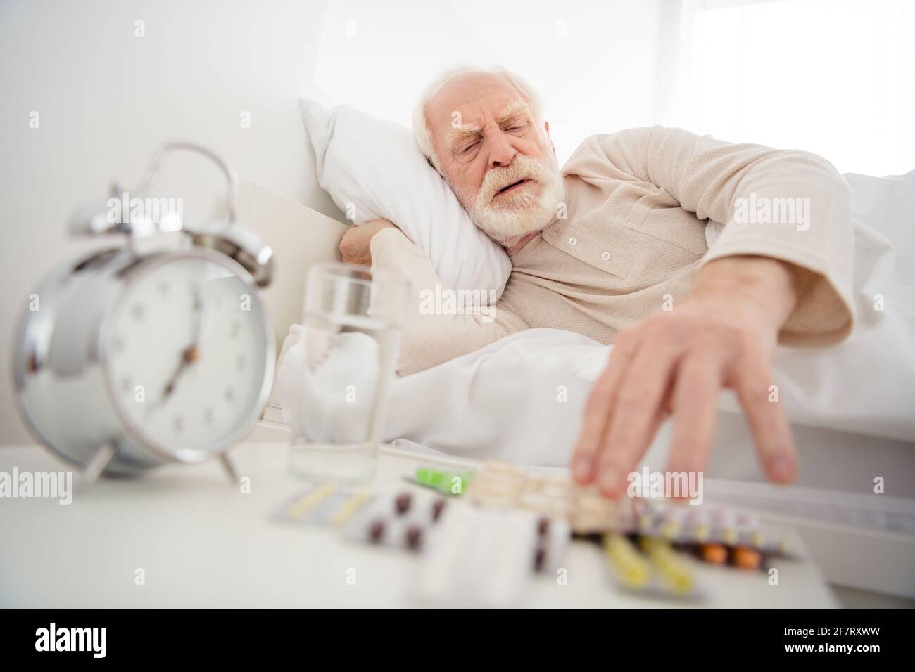 Photo of elderly man pensioner lie bad rest home indoors unwell ...
