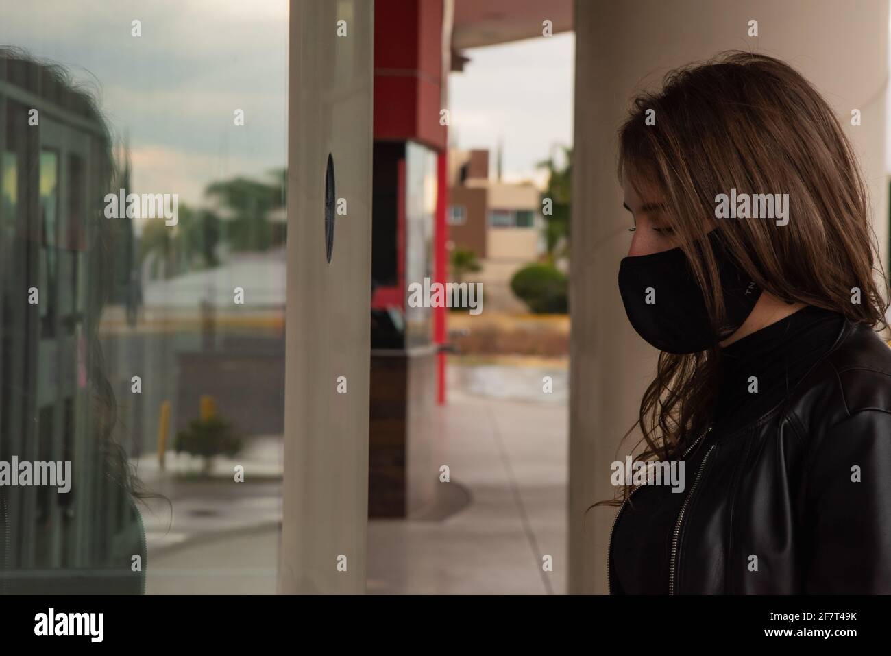 Spanish female in black wearing a face mask outdoors - concept of the ...