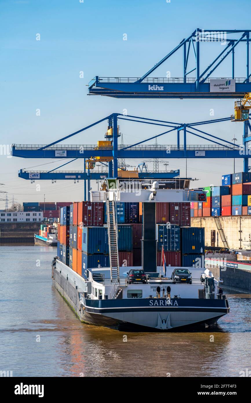 Container cargo ship enters the harbour basin of the Logport, gantry ...