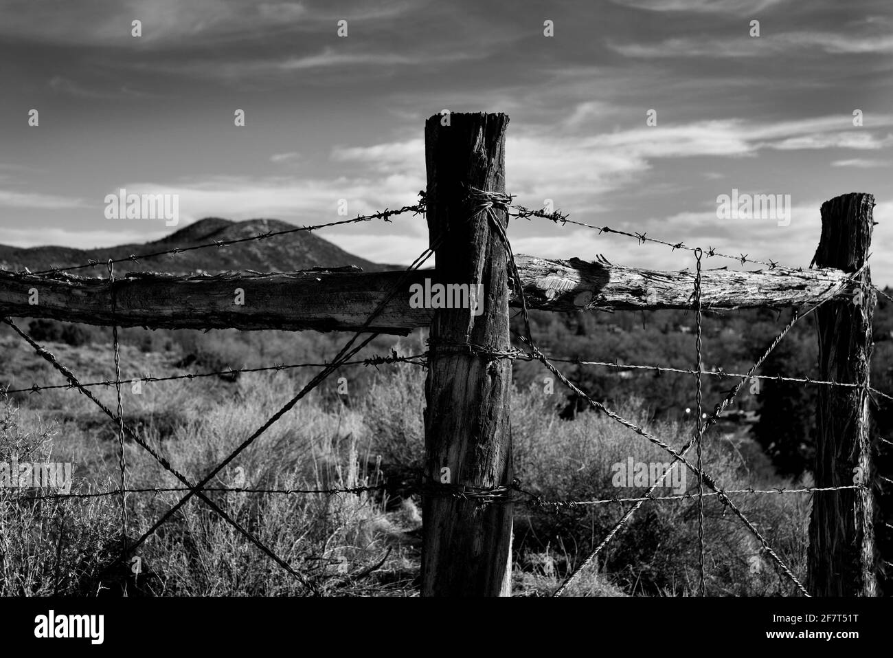 A barbed wire fence designates a boundary line in Santa Fe, New Mexico ...
