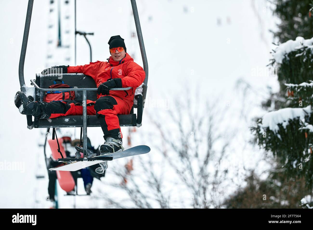 Skier sitting at ski lift in high mountains during sunny day. Winter ...