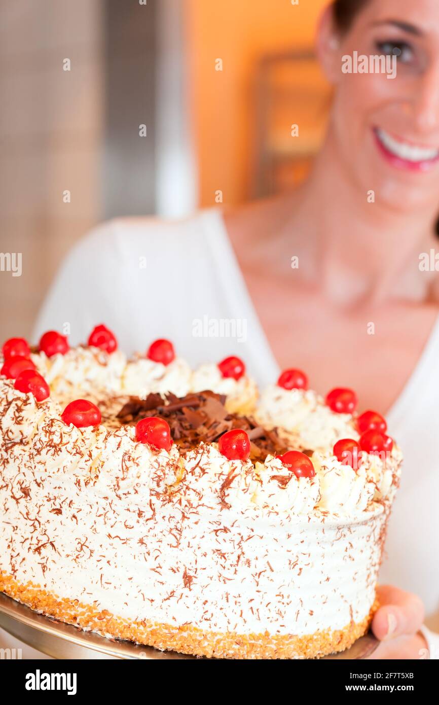 Female baker or pastry chef with torte in bakery Stock Photo - Alamy