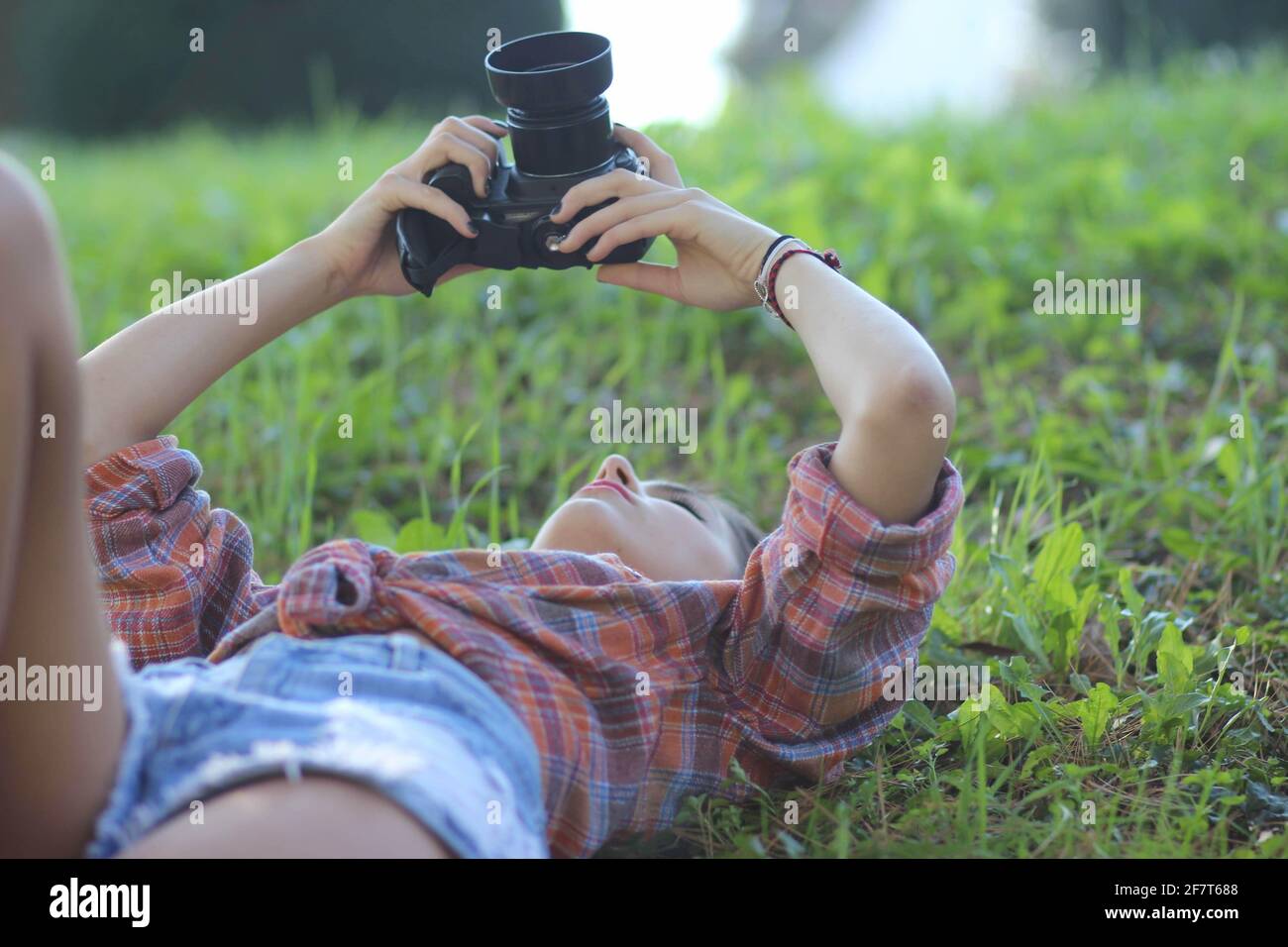 Young caucasian female lying in the grass at a park Stock Photo - Alamy
