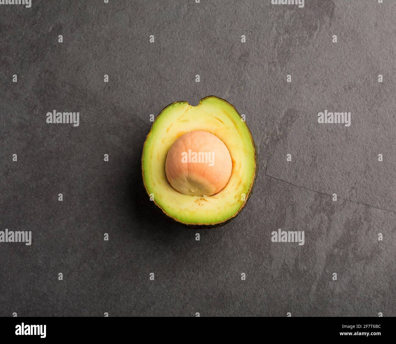 Avocado on gray background - Persea americana 'Hass' Stock Photo - Alamy