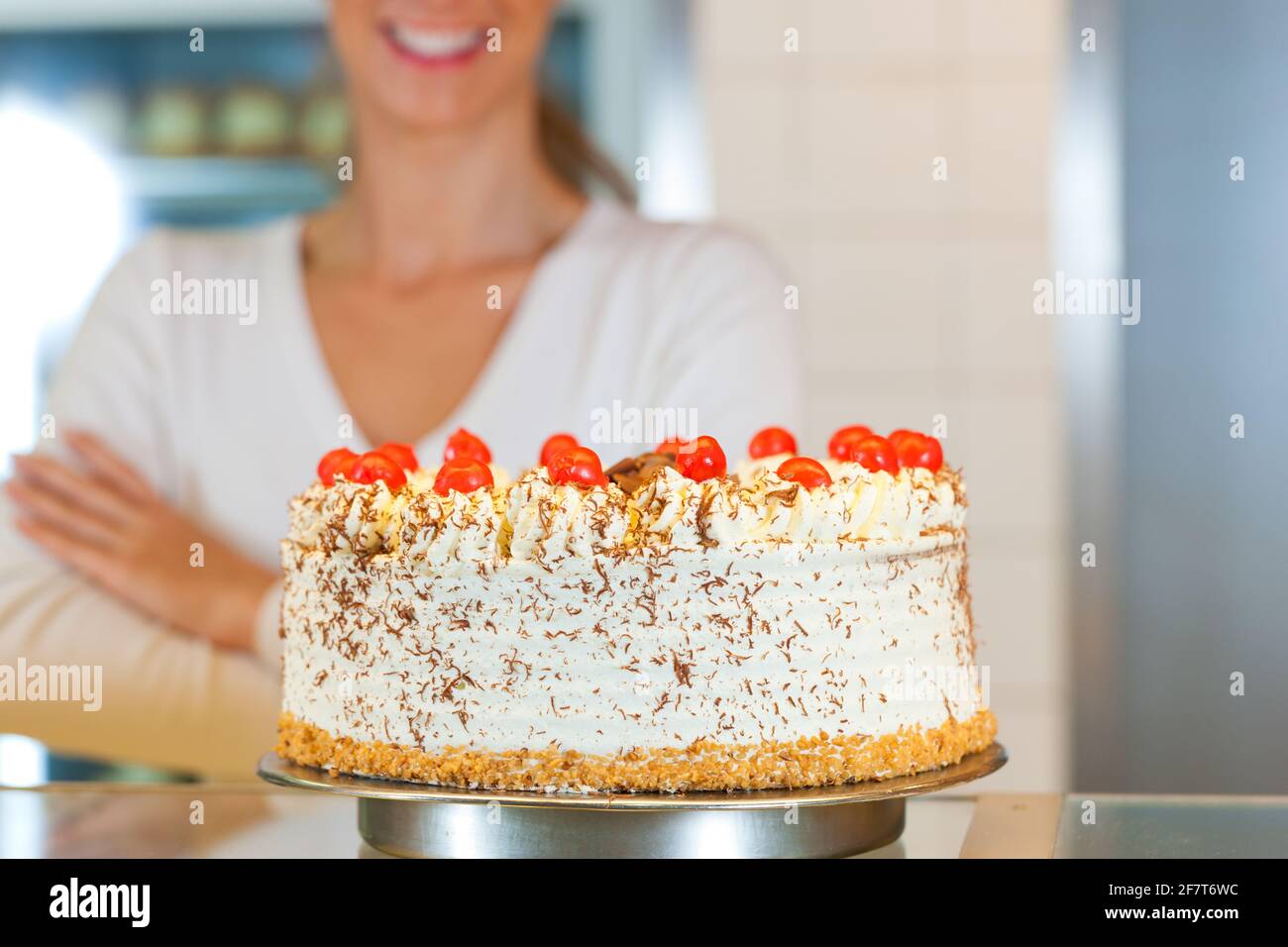 Female baker or pastry chef with torte in bakery Stock Photo - Alamy