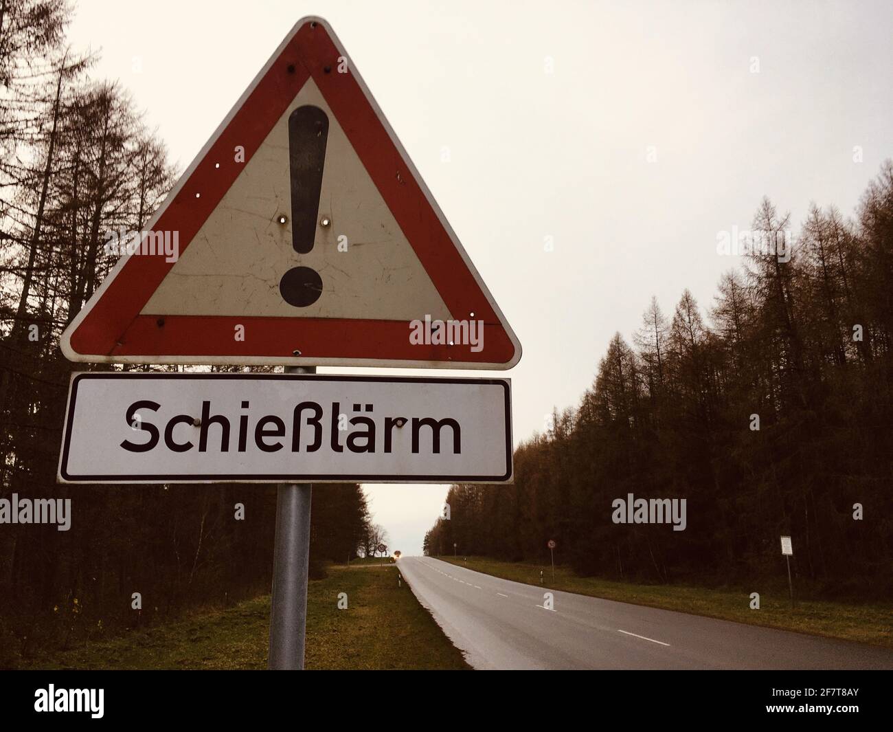 Red warning sign above a "Shooting noise" sign in German on the ...