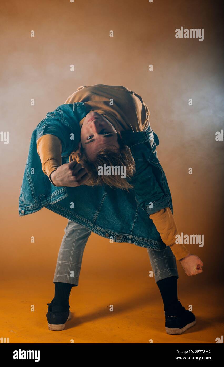 Slender athletic man performing modern style dance moves Stock Photo ...