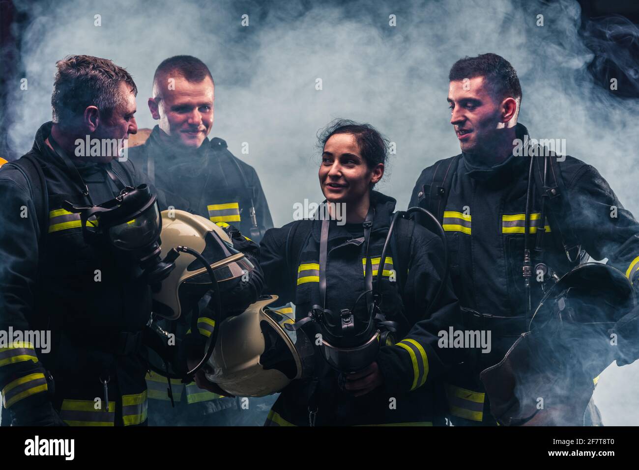 Team of firefighters standing the middle of the fire extinguisher's ...