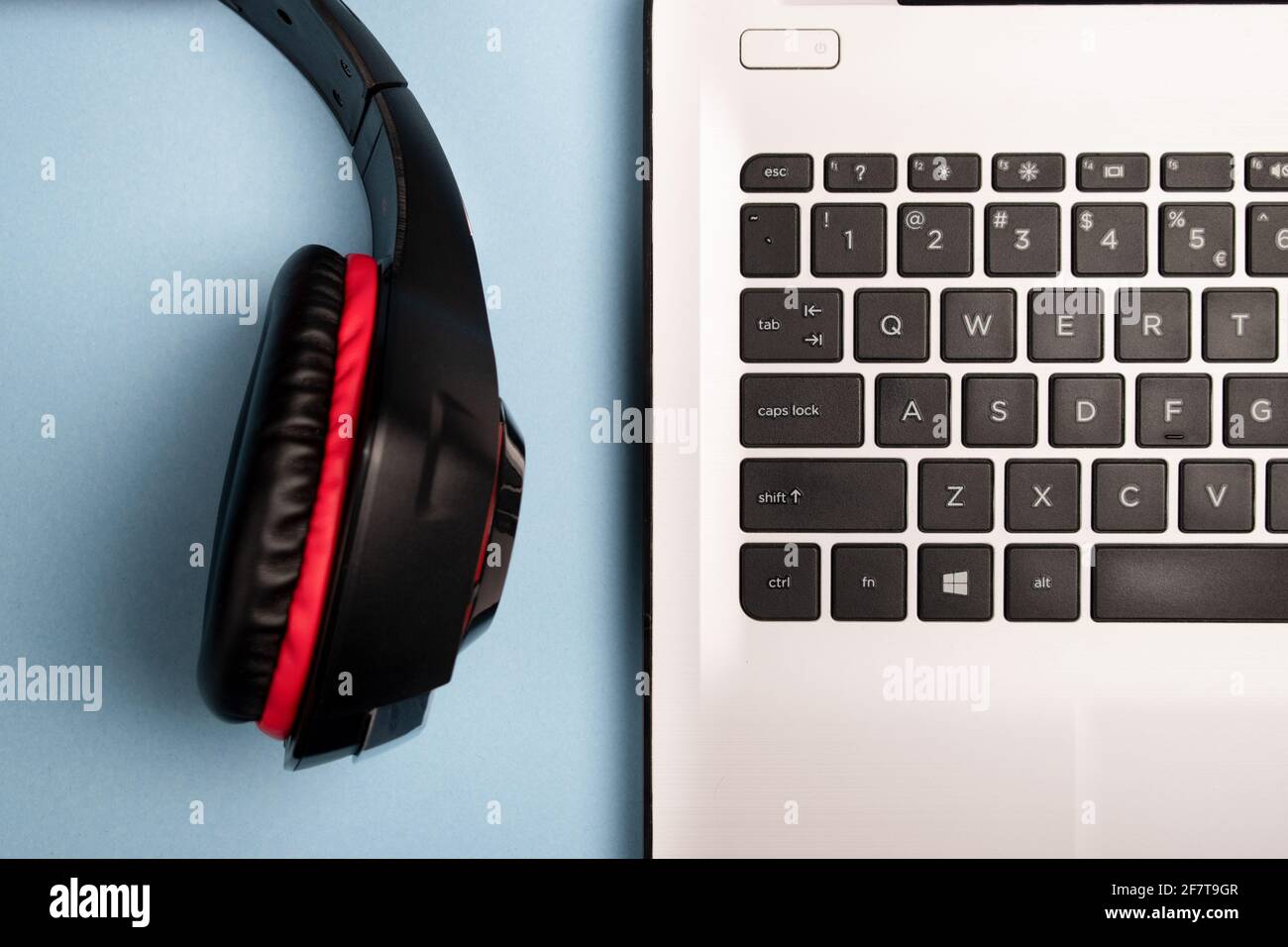Headset next to an open laptop on a blue backgrou Stock Photo - Alamy
