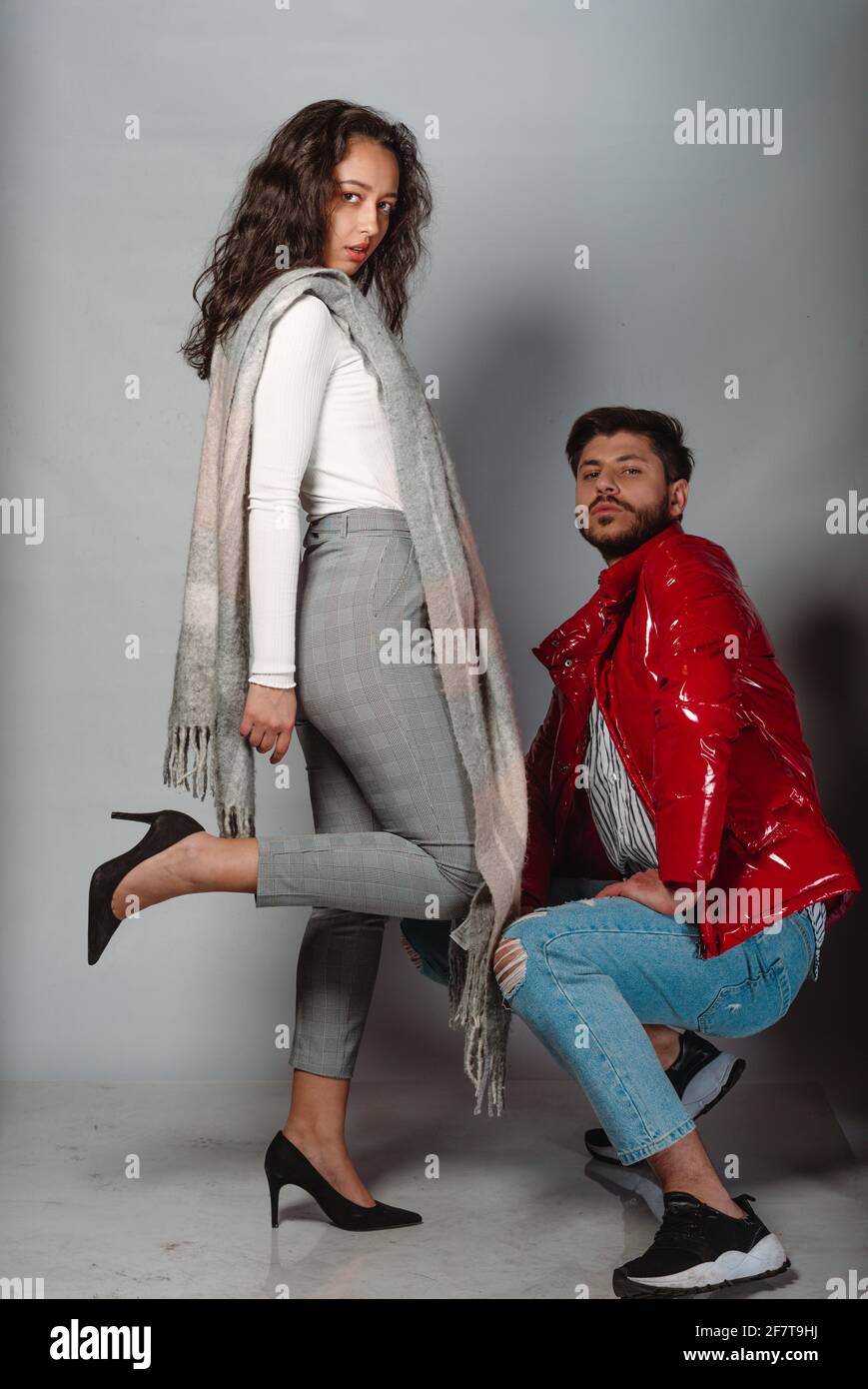 Pair of male and female models in modern clothes posing side by side ...