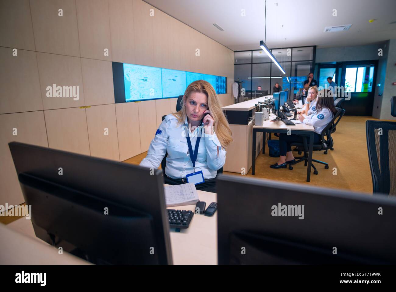 Female security guards working on computers while sitting in the main ...