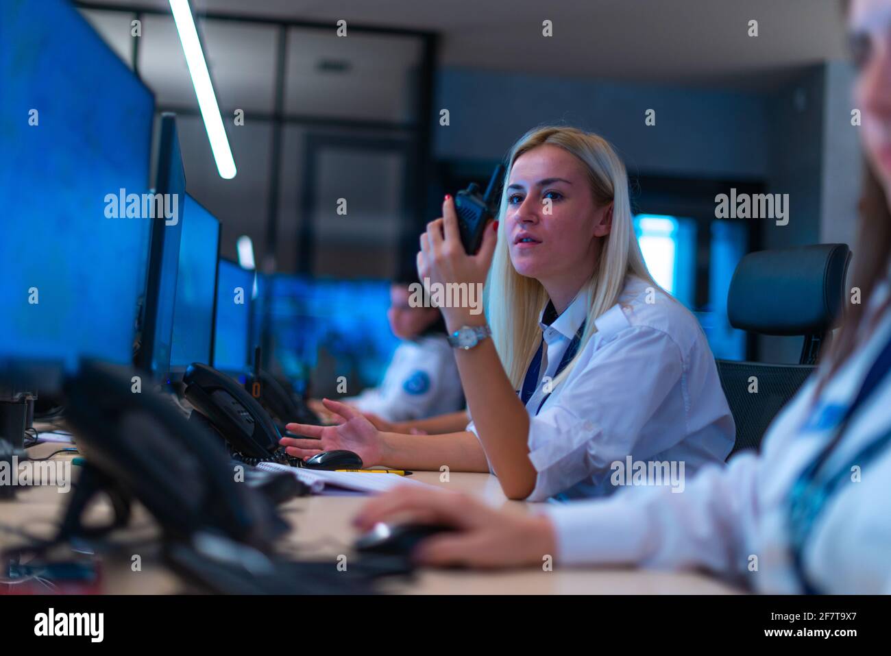 Happy security data center operator colleagues (coworkers) smiling and ...