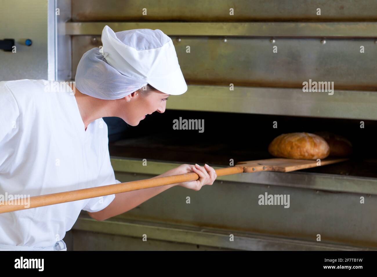 Female baker baking bread Stock Photo - Alamy