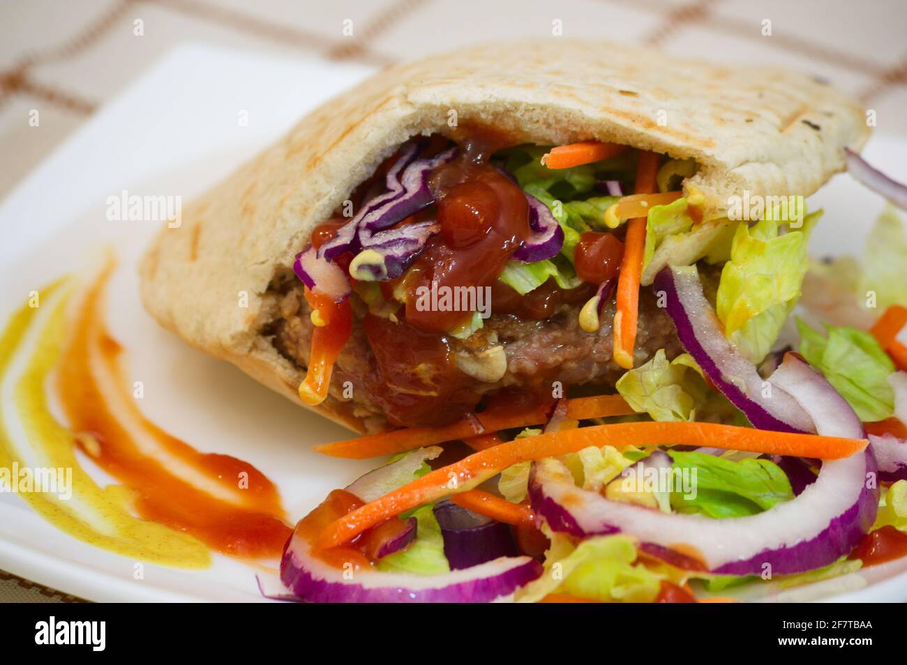 Image of a hamburger seasoned with ketchup, purple onion rings and ...