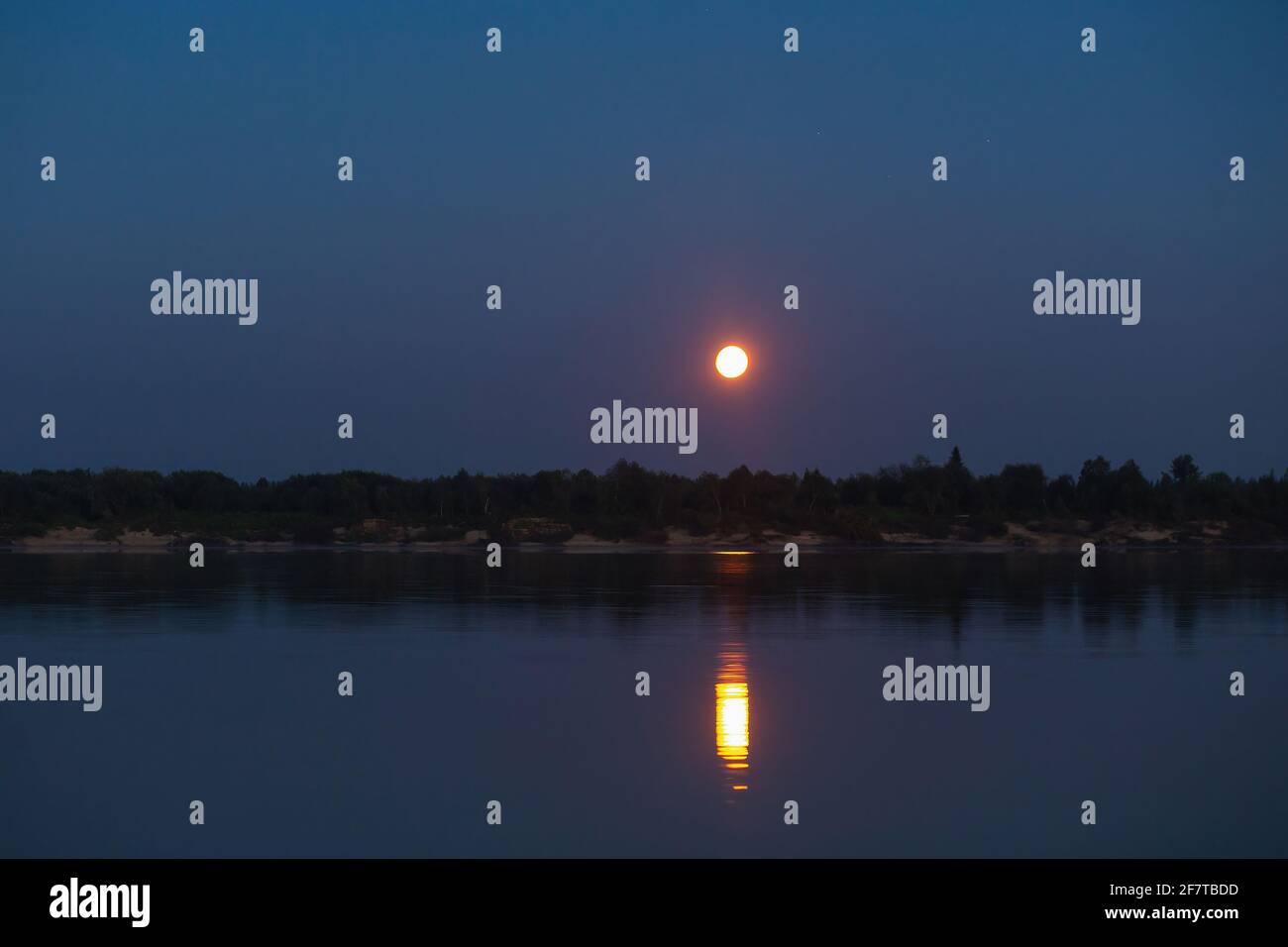 Natural landscape with night sky and yellow moon reflected in water in ...