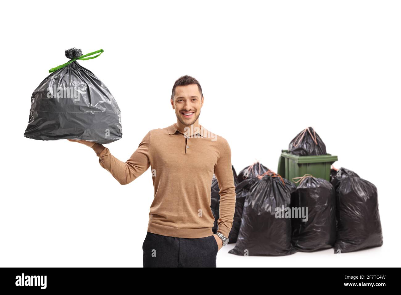 Young man holding a garbage bag in front of a waste bin isolated on ...