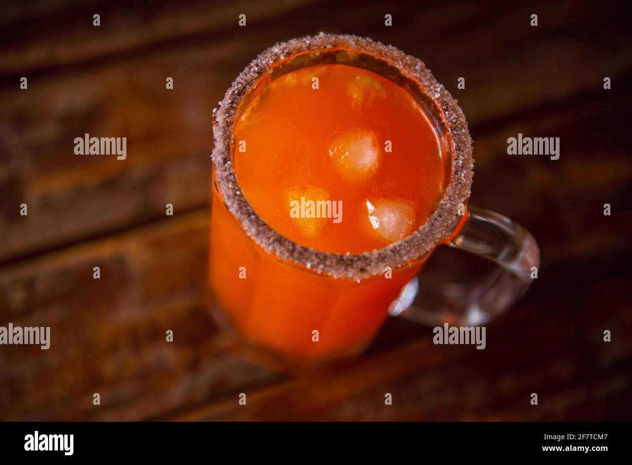 Top view of a fresh Mexican spicy Michelada drink in a salt-rimmed ...