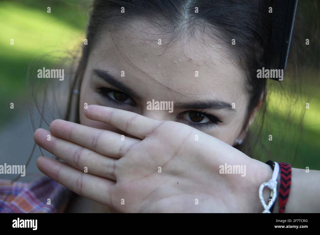 Portrait of a young caucasian female closing her face with her hand ...