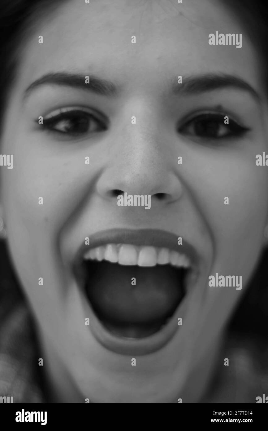Vertical greyscale shot of the face of a young caucasian female with an ...