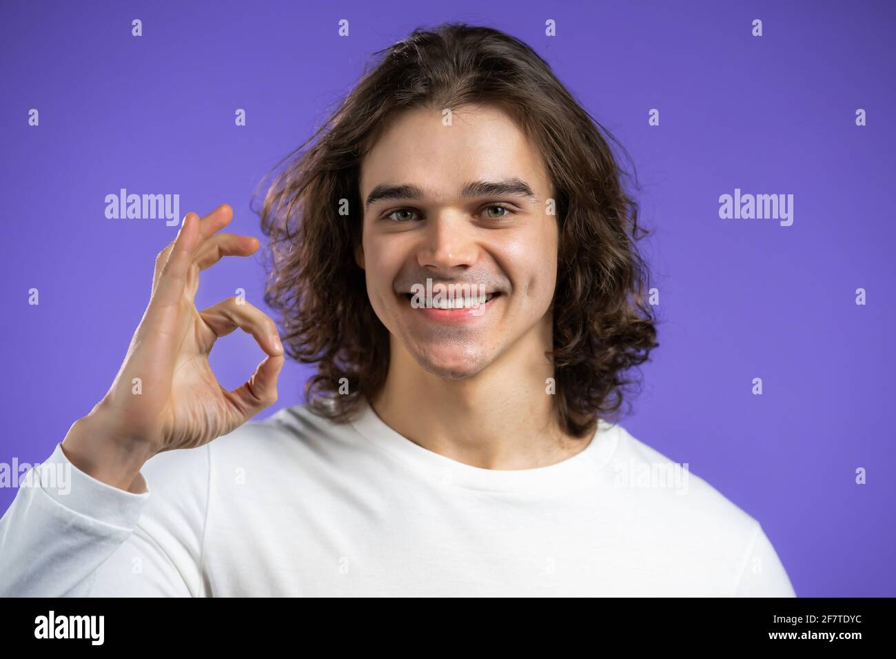 Handsome man shows okay, ok gesture. Happy guy on violet background ...