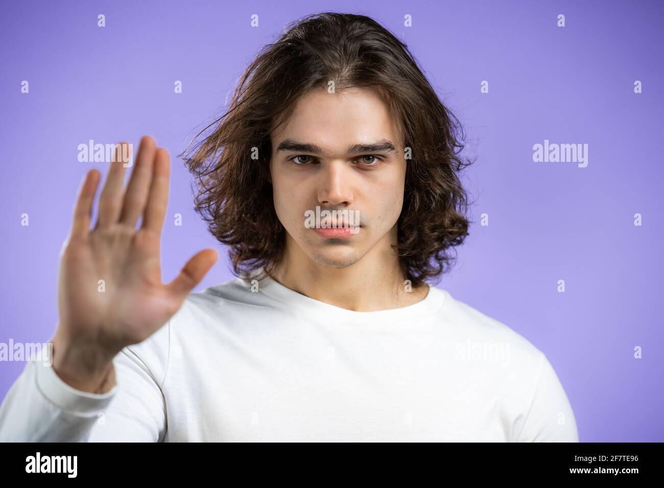 Portrait of serious man showing rejecting gesture by stop palm hand ...