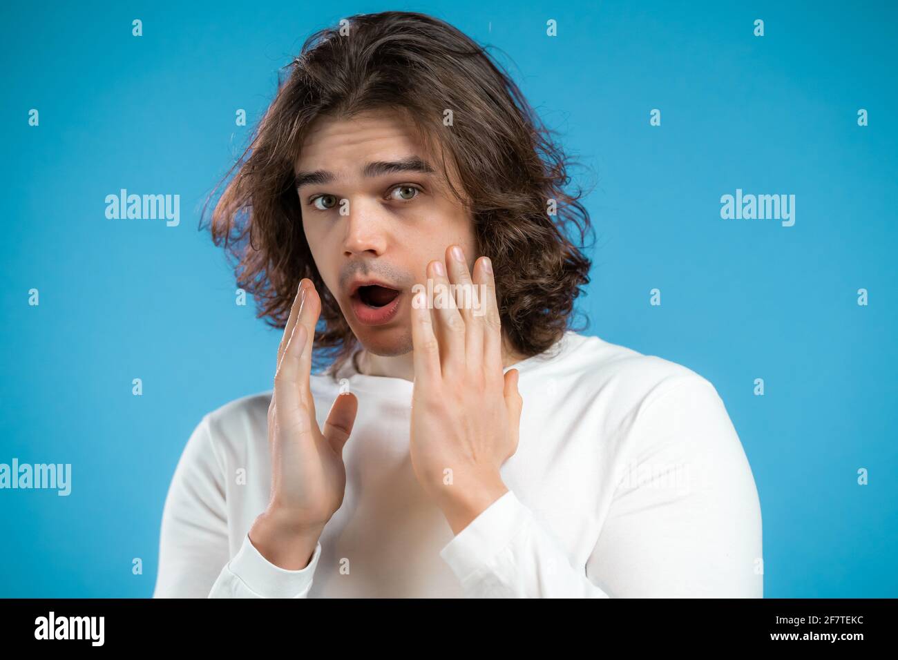 Frightened man shocked isolated on blue background. Stressed and ...