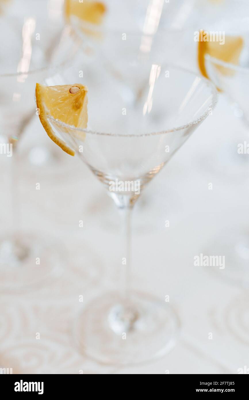 empty cocktail glasses with lemon slices for martini Stock Photo - Alamy