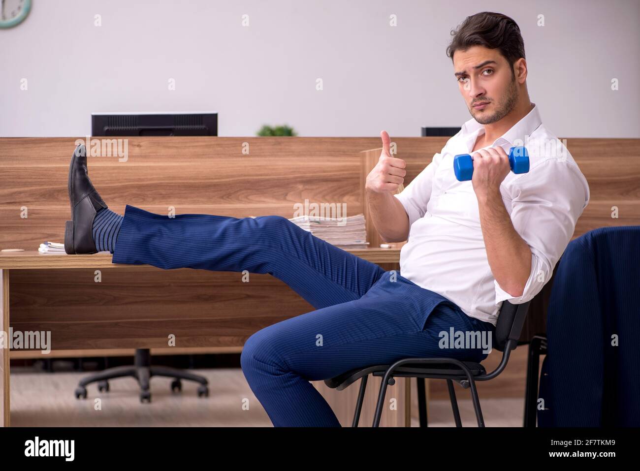 Young male employee doing sport exercises in the office Stock Photo - Alamy