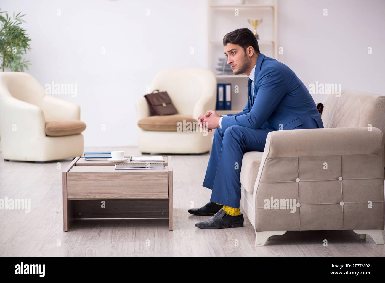 Young male employee waiting for business meeting Stock Photo - Alamy