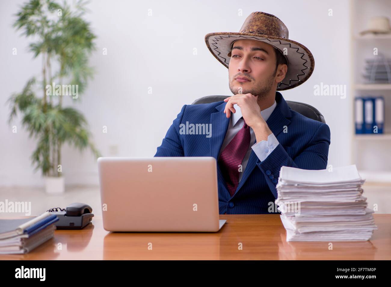 Young cowboy employee working at workplace Stock Photo - Alamy