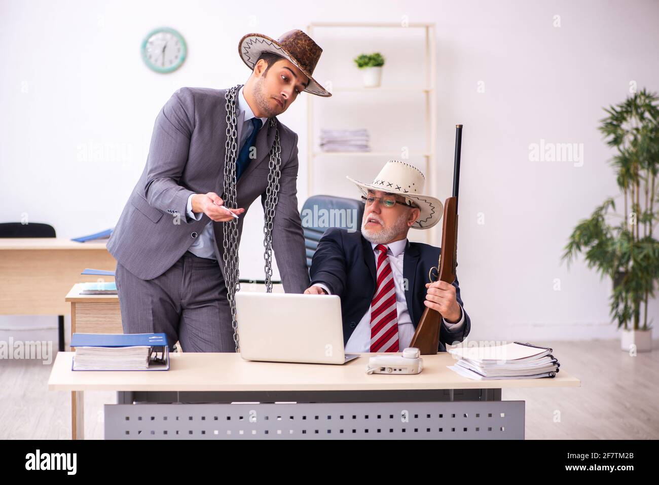 Two cowboy employees in funny concept Stock Photo - Alamy