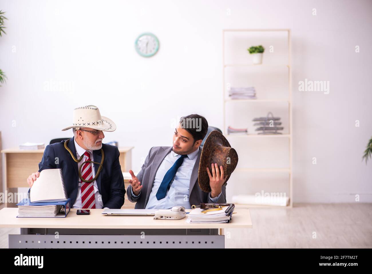 Two cowboy employees in funny concept Stock Photo - Alamy