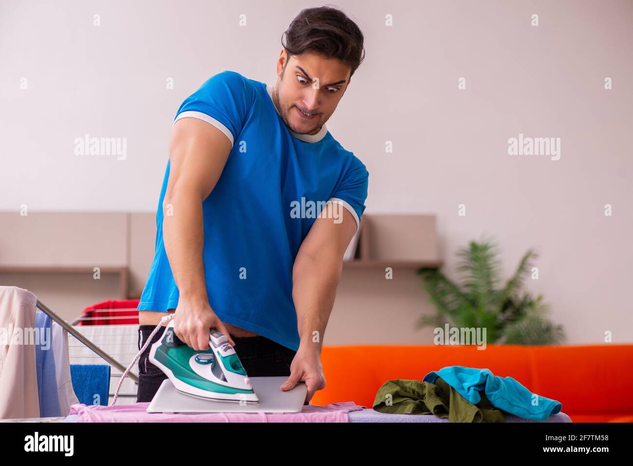 Young man doing ironing at home Stock Photo - Alamy