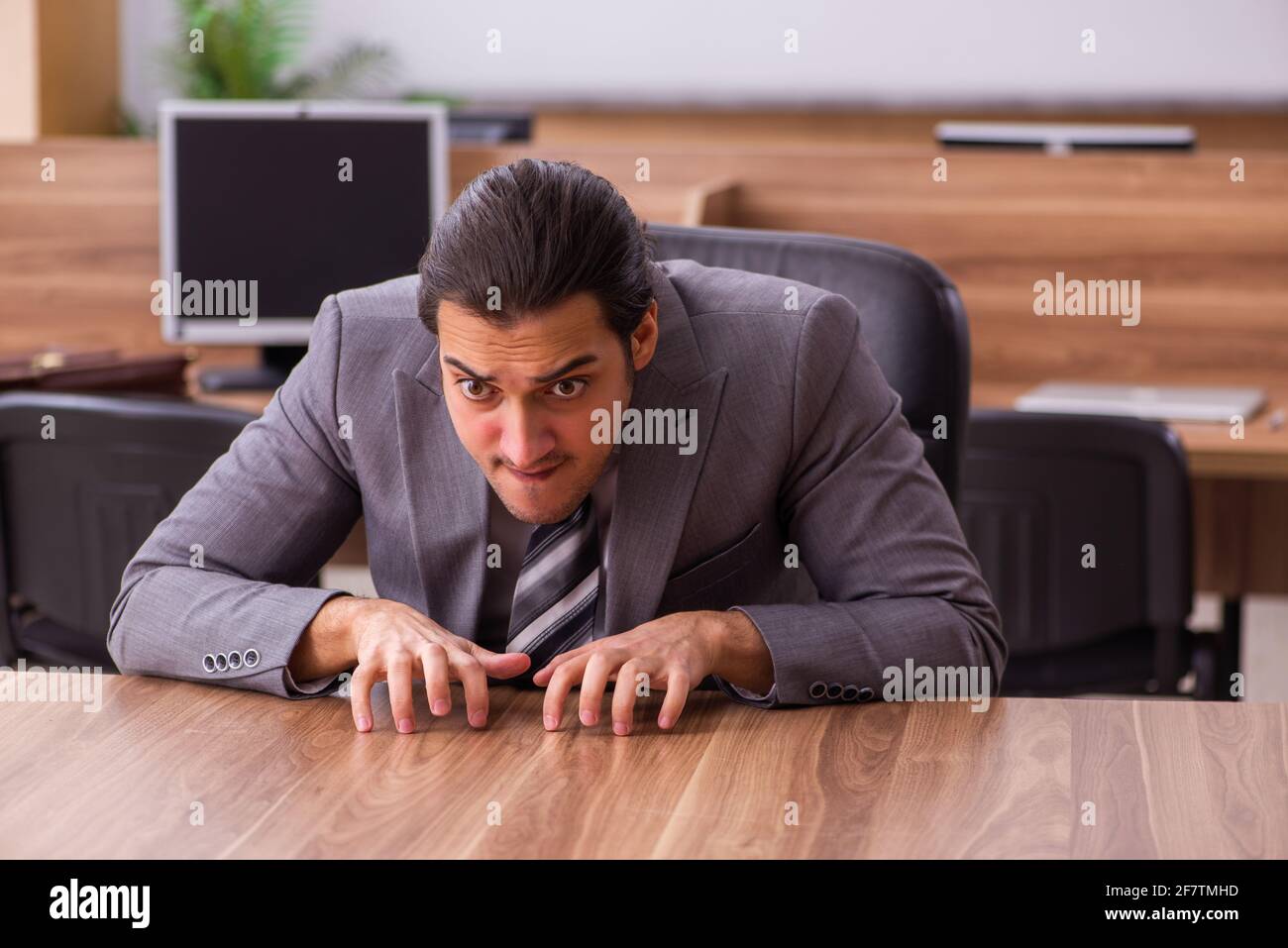 Young male employee working at workplace Stock Photo - Alamy