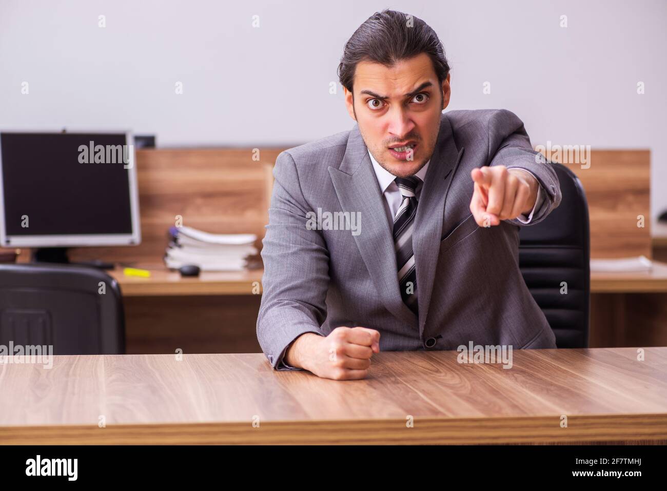 Young male employee working at workplace Stock Photo - Alamy