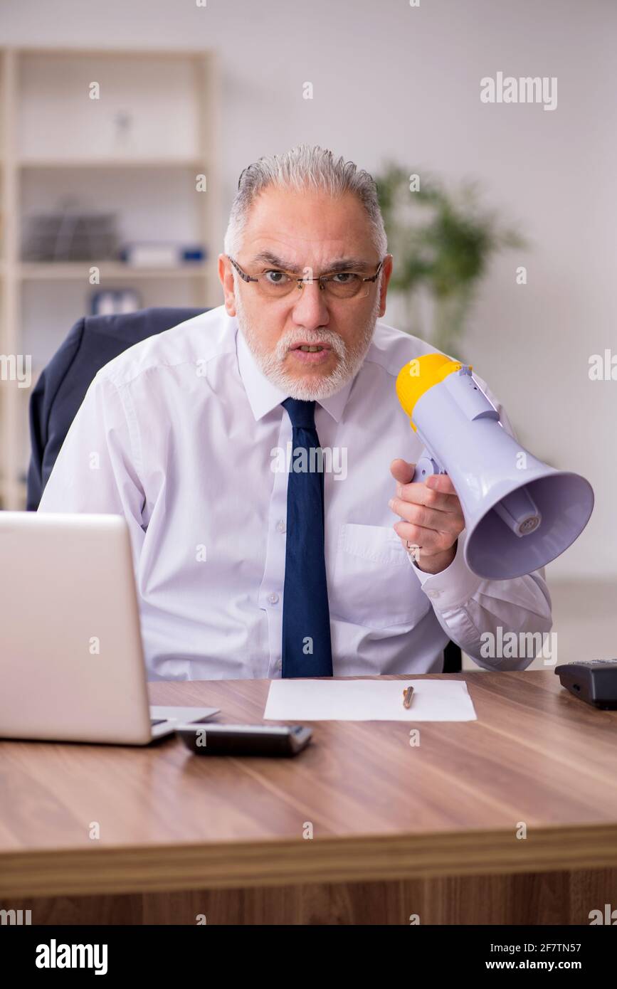 Old businessman employee holding megaphone at workplace Stock Photo - Alamy