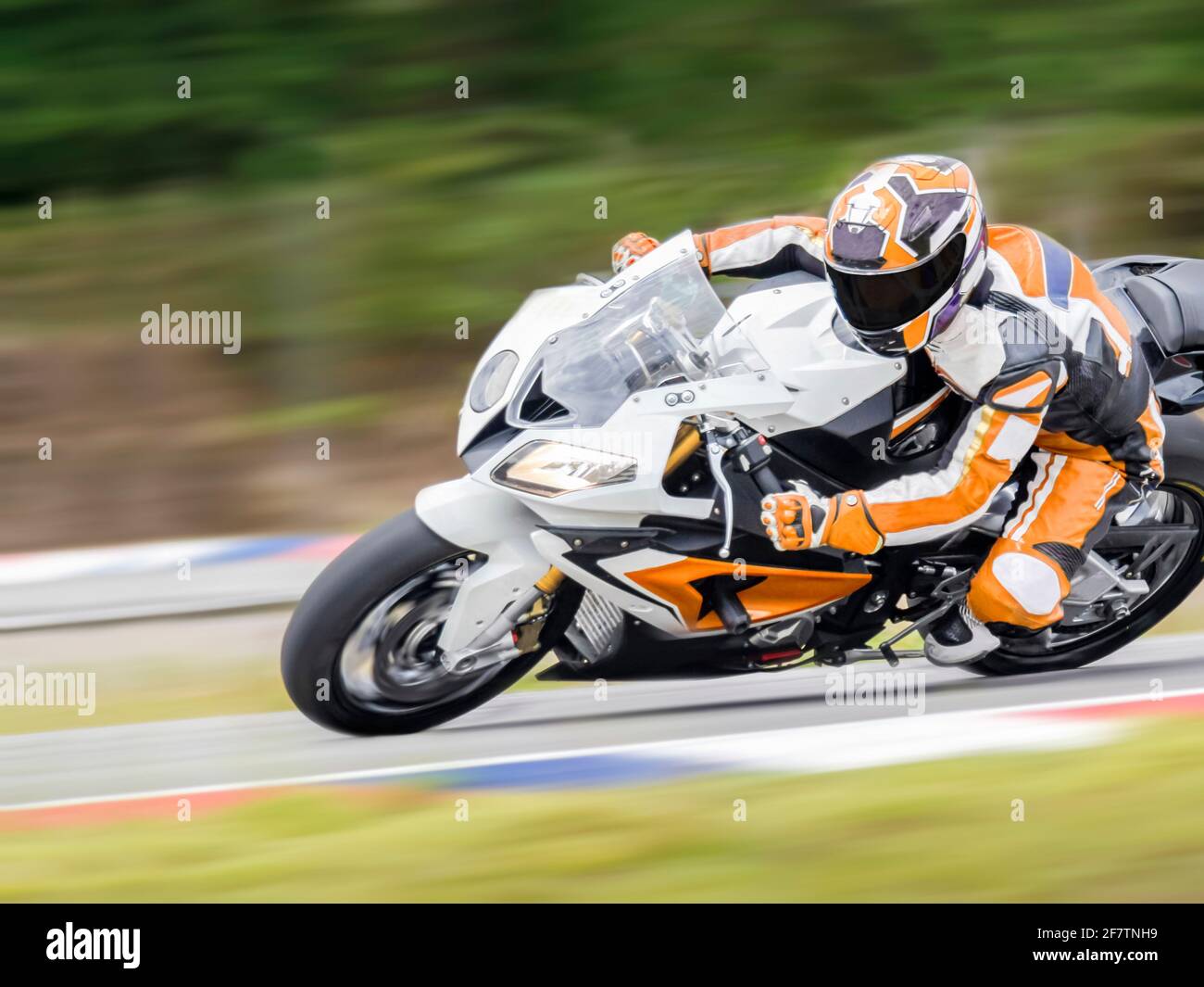 Motorcycle practice leaning into a fast corner on track Stock Photo - Alamy