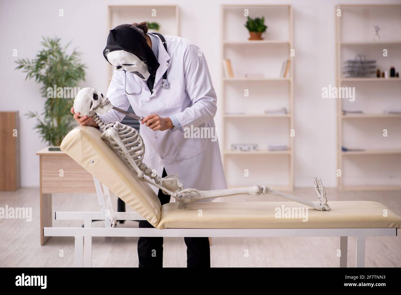 Devil doctor examining skeleton patient in the clinic Stock Photo - Alamy