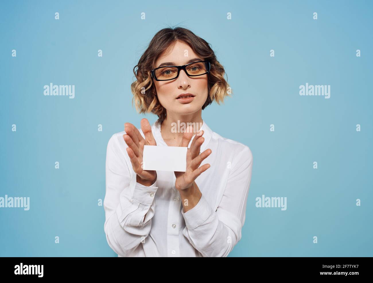 Woman holding business card blue background mockup Stock Photo - Alamy