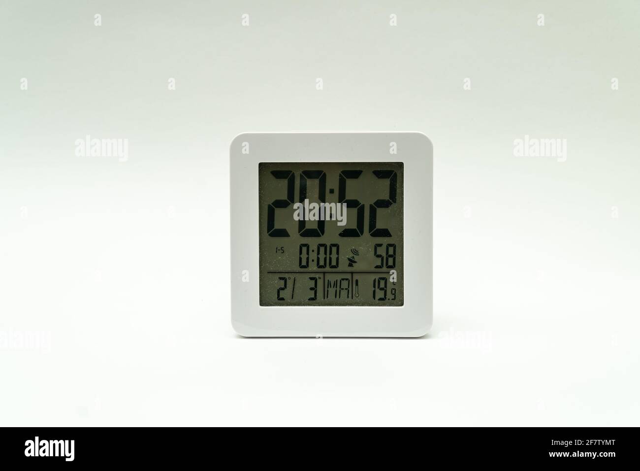 Closeup shot of a plain white alarm clock showing the time on a clean ...