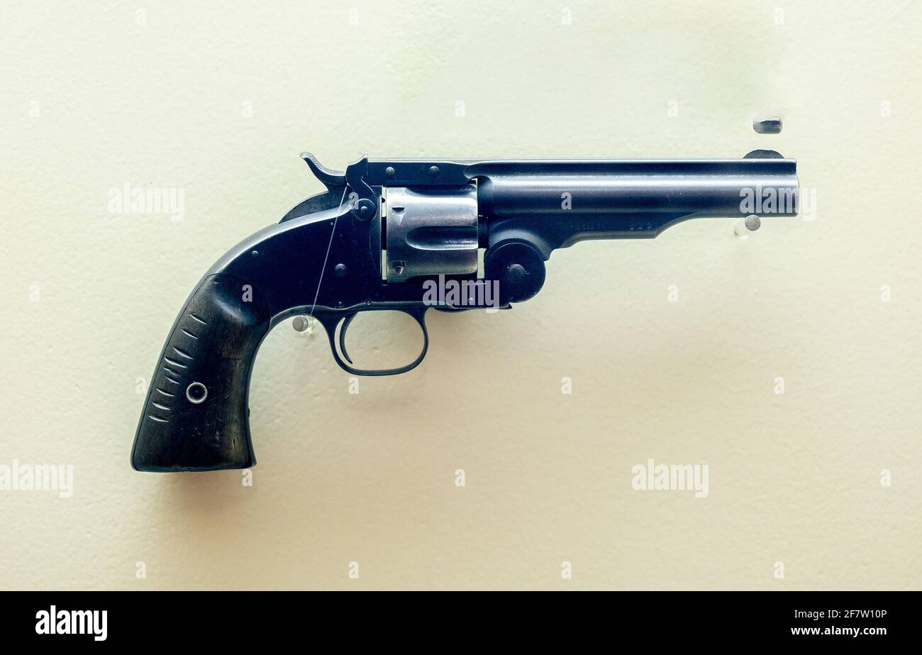 Revolver gun isolated on a light yellow background Stock Photo - Alamy