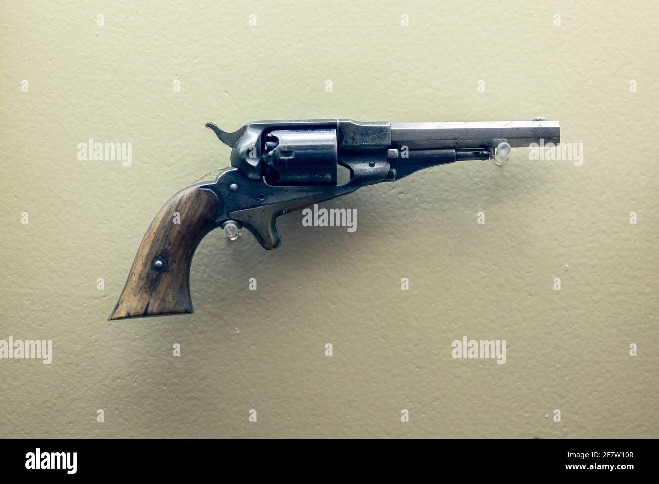 Revolver gun isolated on a light yellow background Stock Photo - Alamy