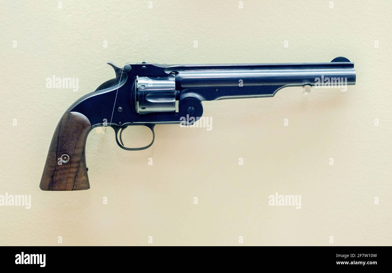 Revolver gun isolated on a light yellow background Stock Photo - Alamy