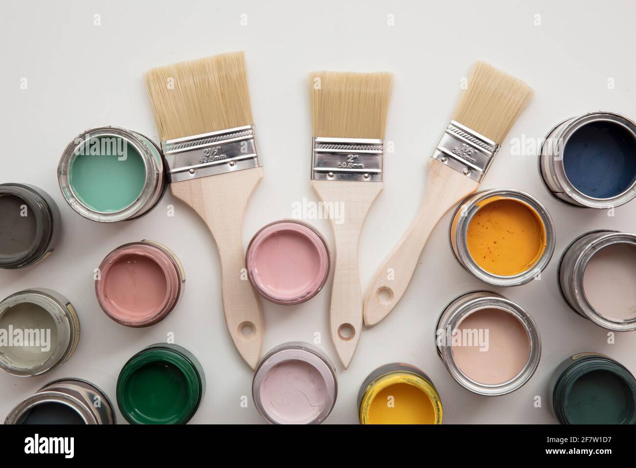 Overhead view of a DIY paint brush with colorful sample paint pots ...