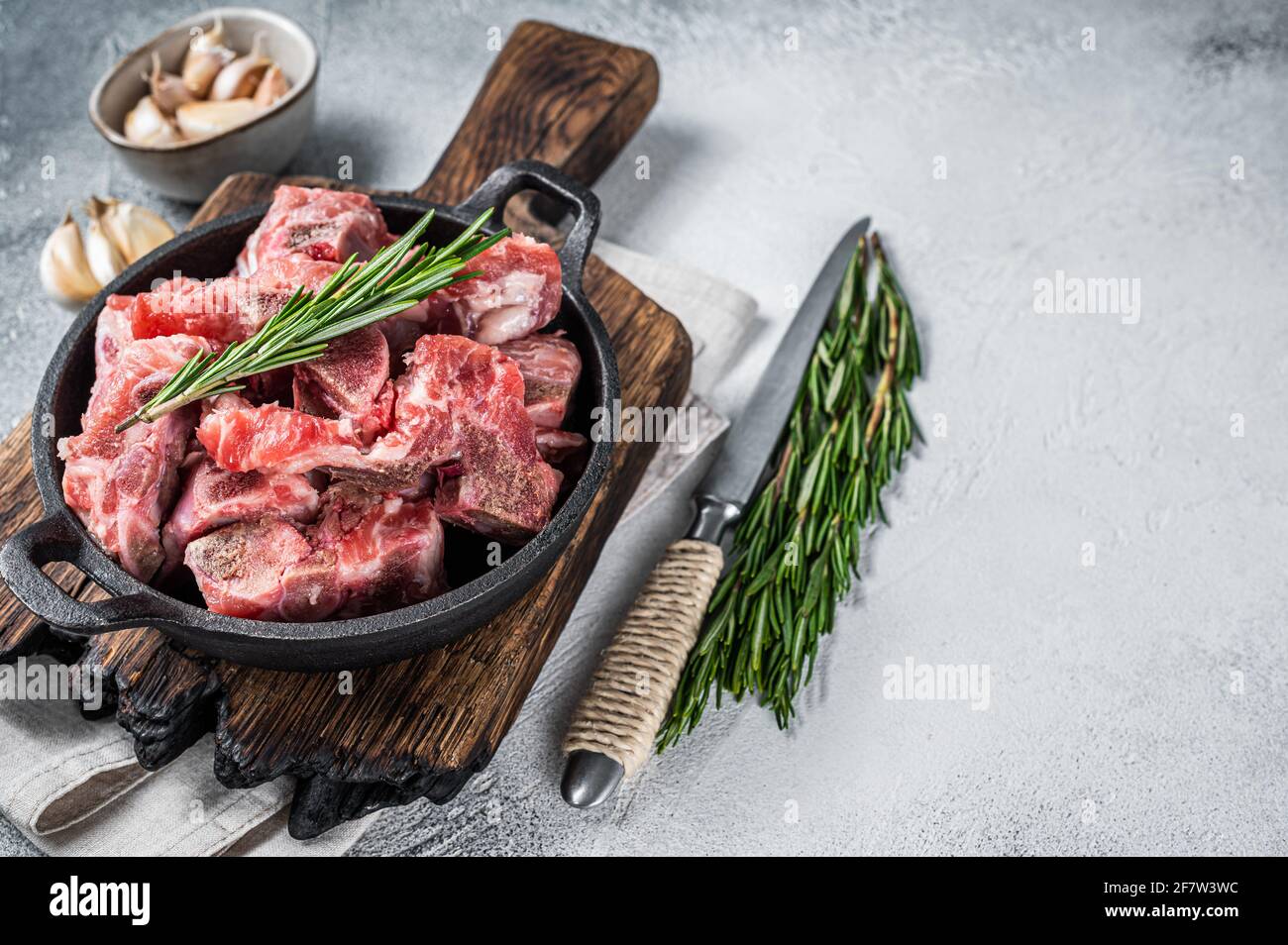 Raw diced meat cubes with bone in a pan. White background. Top View ...